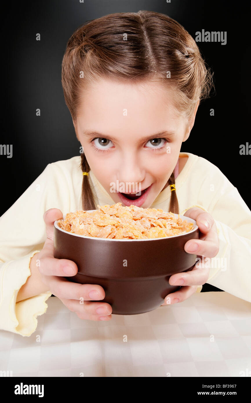Portrait of a girl holding a bowl of corn flakes Stock Photo - Alamy