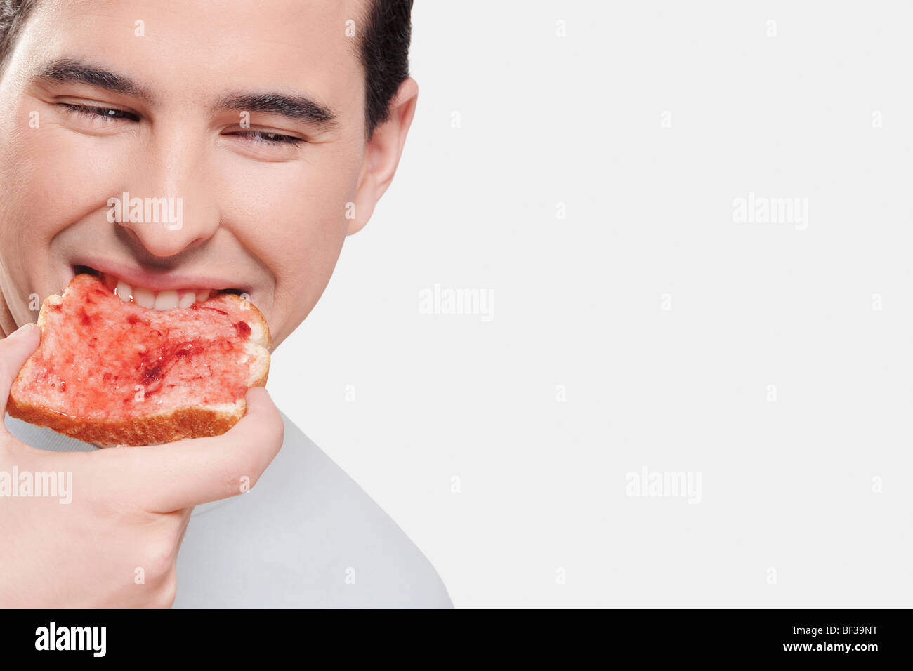 Man eating jam on toast Stock Photo - Alamy