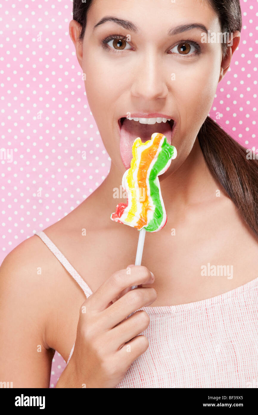 Portrait of a woman eating a lollipop Stock Photo - Alamy