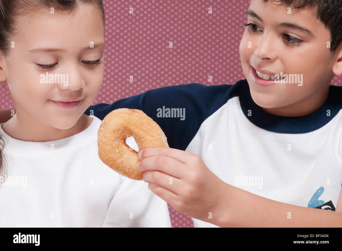 Close up boy feeding donut sister hi-res stock photography and images ...