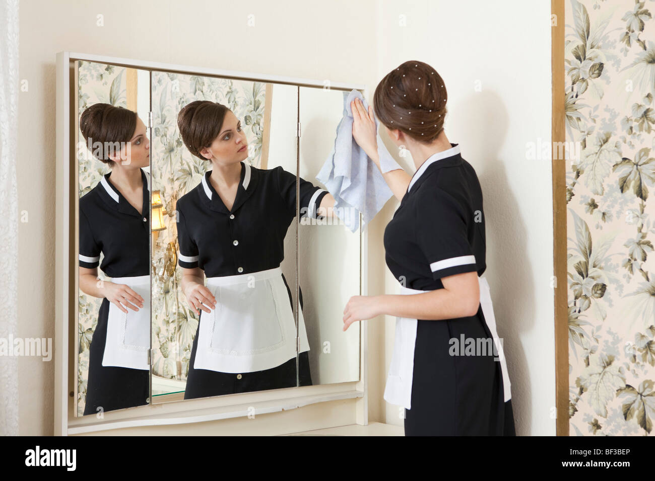 room maid cleaning mirror Stock Photo - Alamy