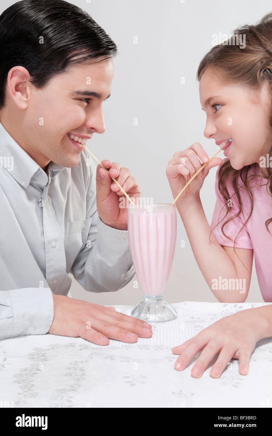 Man and his daughter sharing a milkshake Stock Photo - Alamy