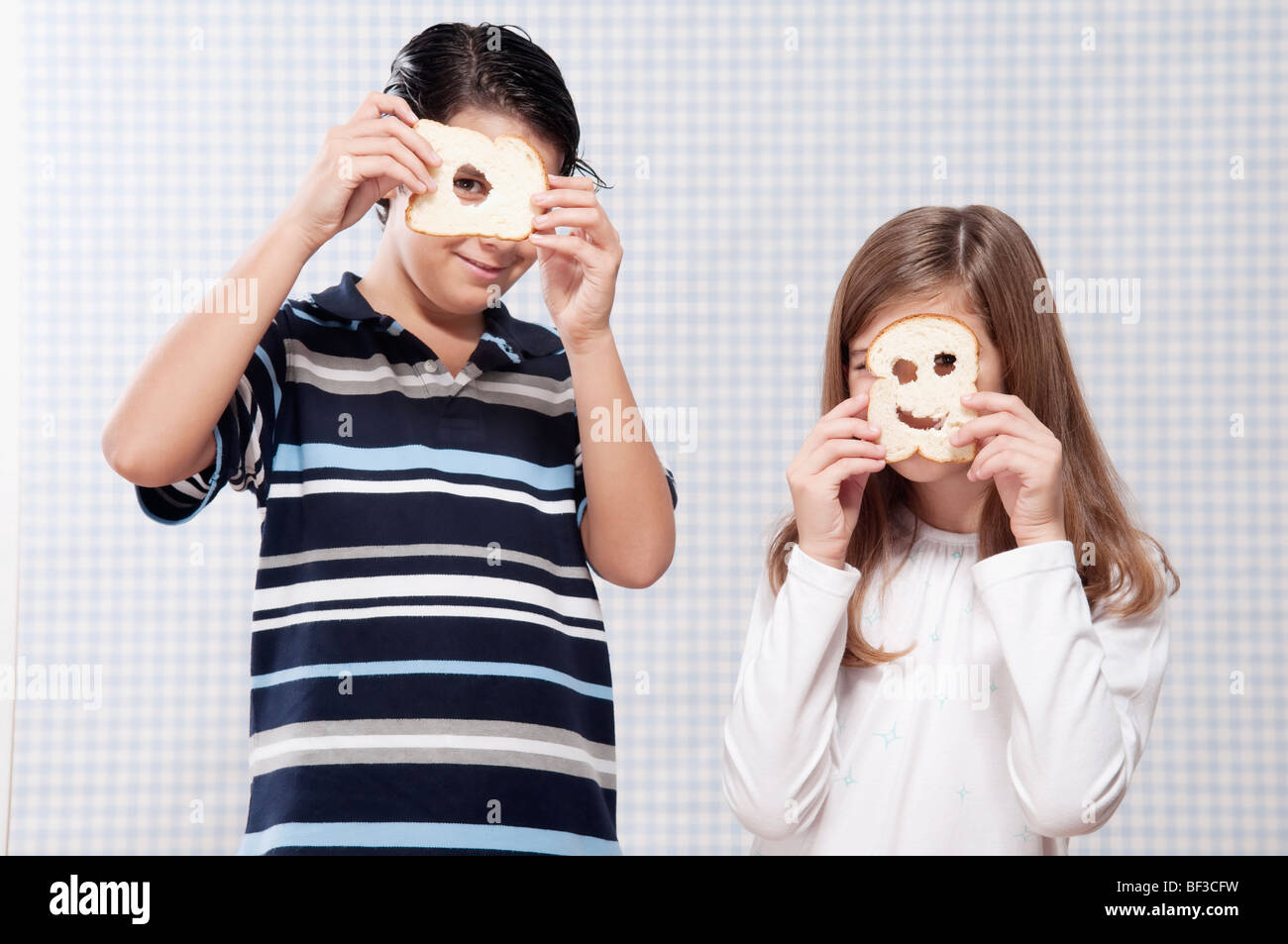 Two children hiding their faces with slices of bread Stock Photo - Alamy