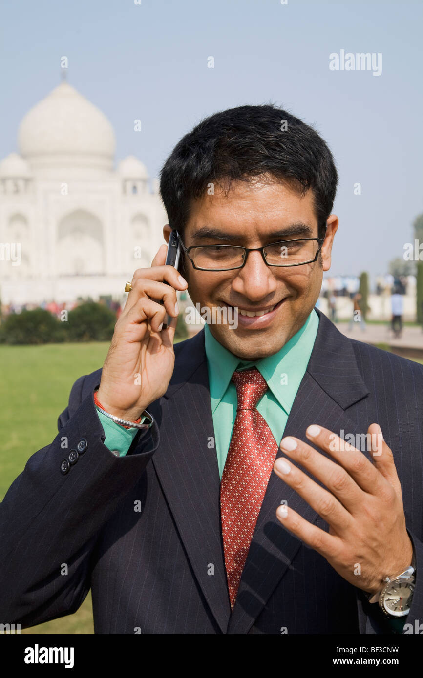 Indian businessman talking on cell phone at the Taj Mahal Stock Photo ...
