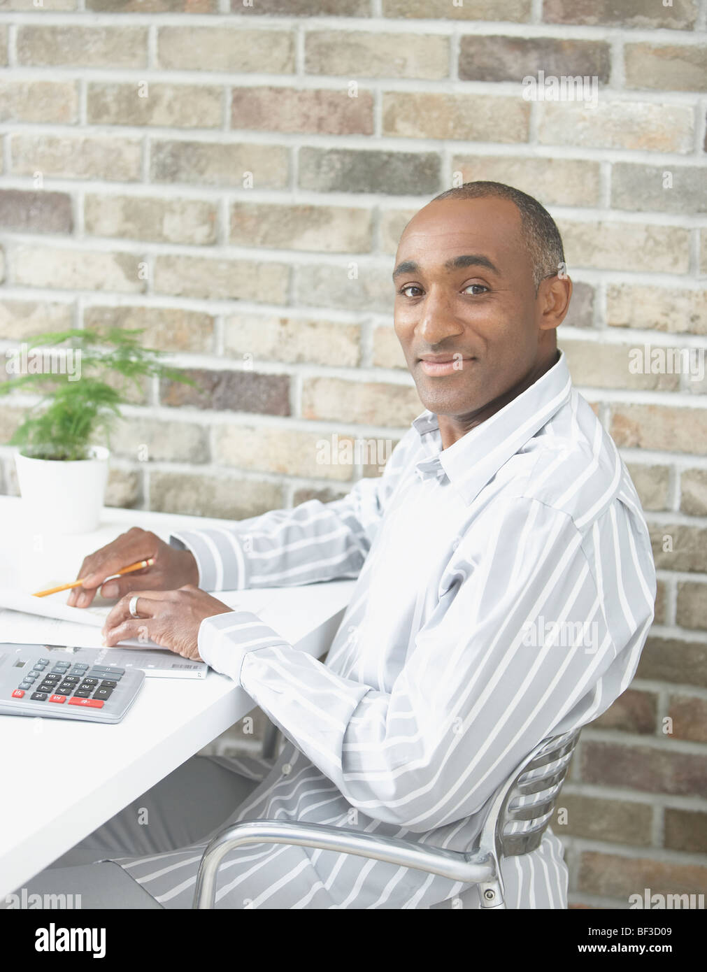 African man with calculator at table Stock Photo - Alamy