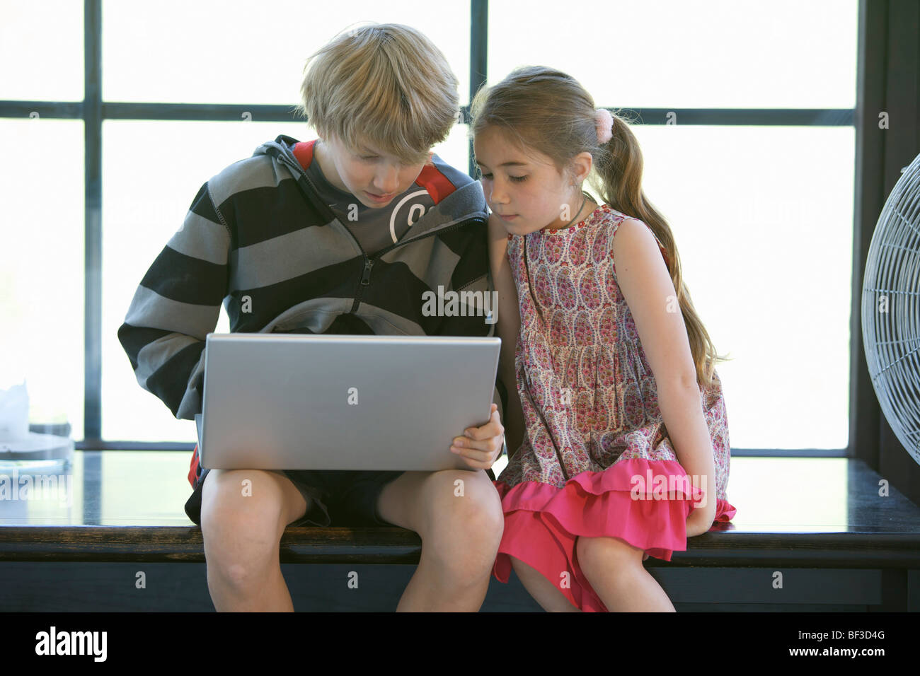 Girl and boy on computer at house Stock Photo - Alamy