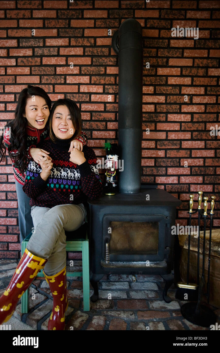 Chinese mother and daughter hugging near fireplace Stock Photo - Alamy