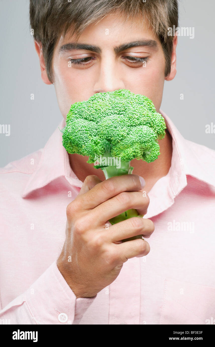 Close-up of a man smelling a broccoli Stock Photo - Alamy