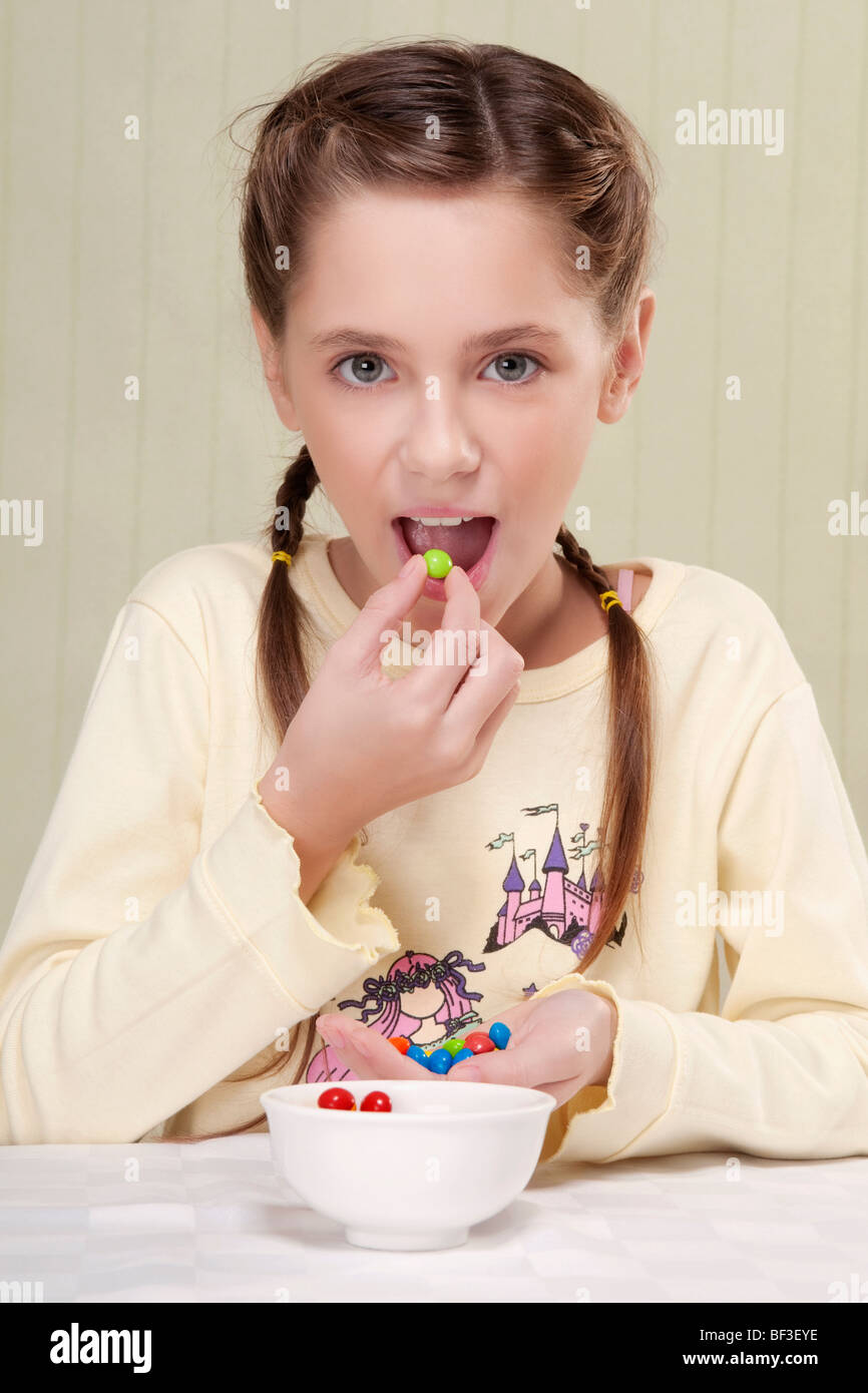 Portrait of a girl eating candies Stock Photo - Alamy