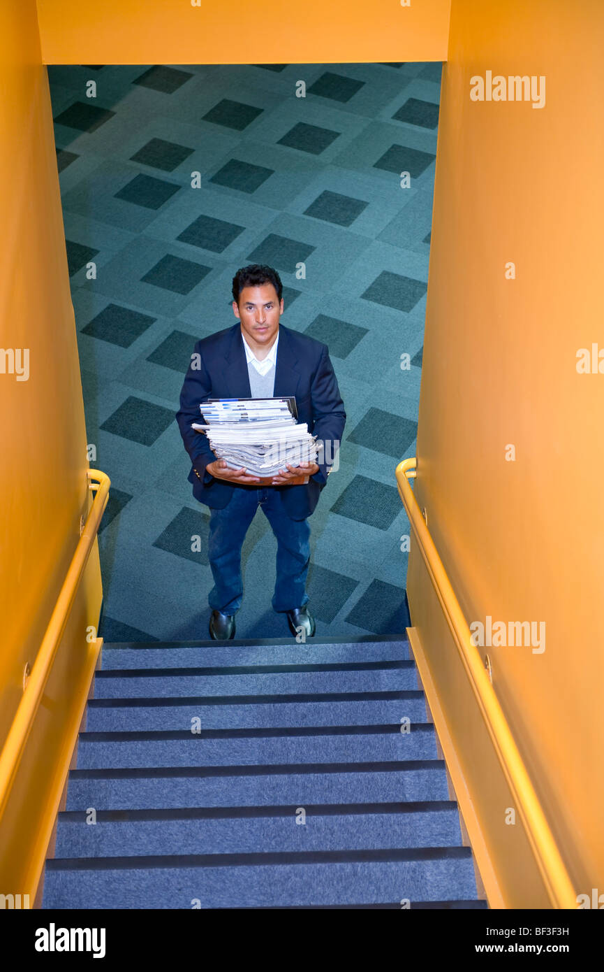 Office worker carrying stack of papers Stock Photo - Alamy