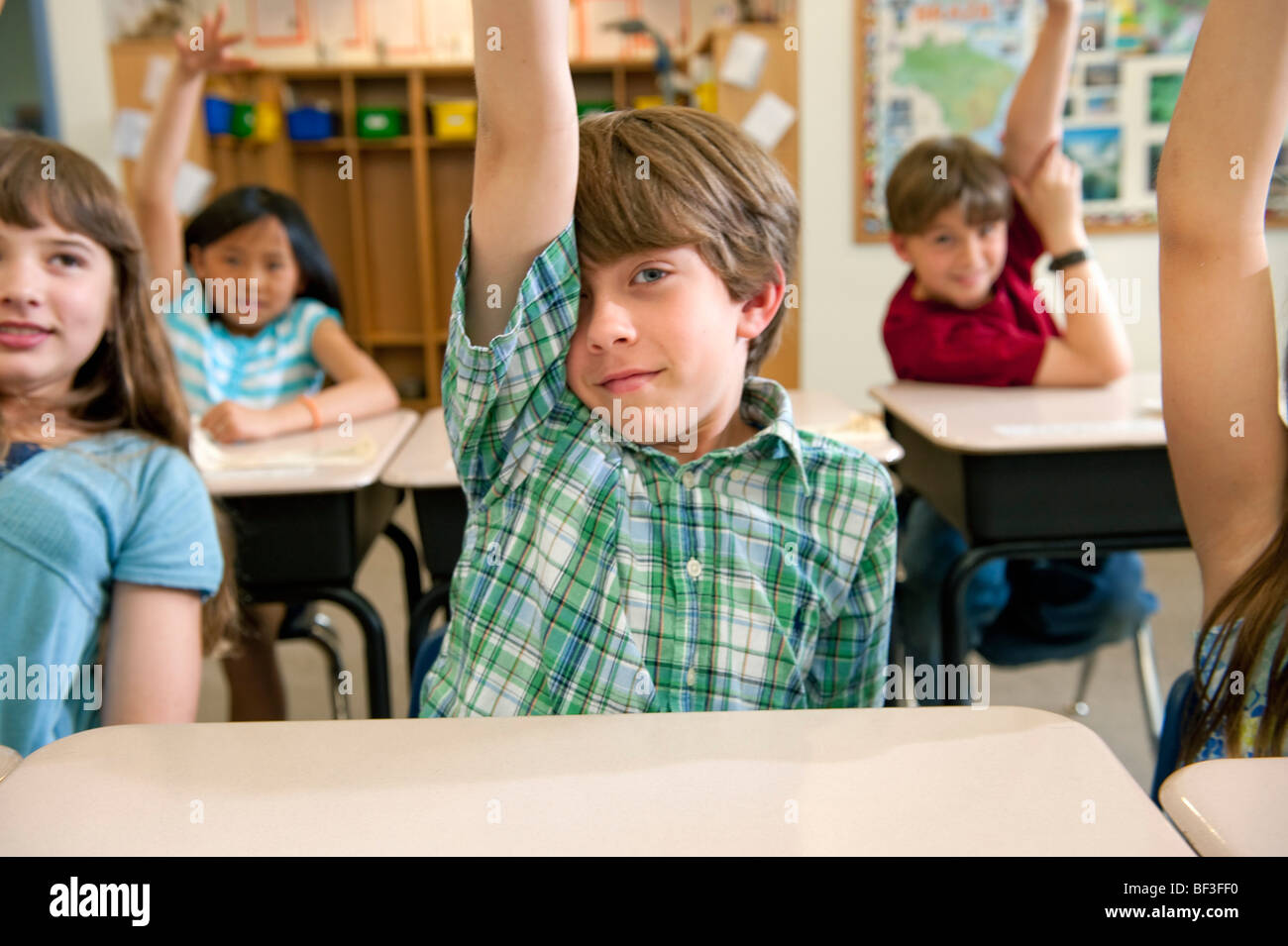 Students raising hands in class Stock Photo - Alamy