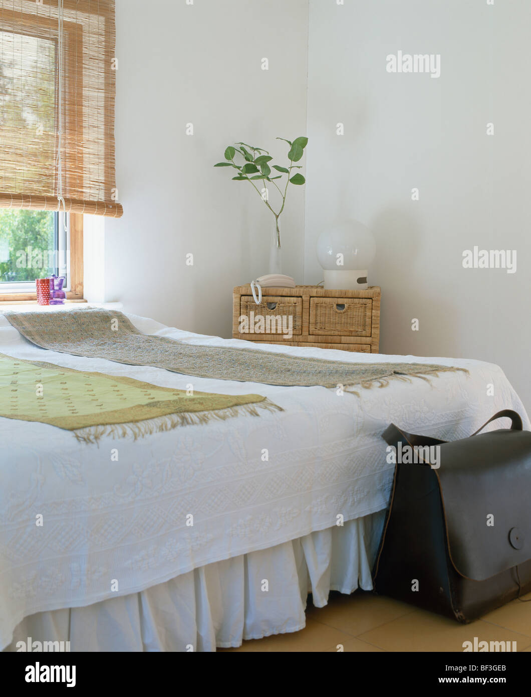 Small yellow and beige throws on white quilt in modern white country ...