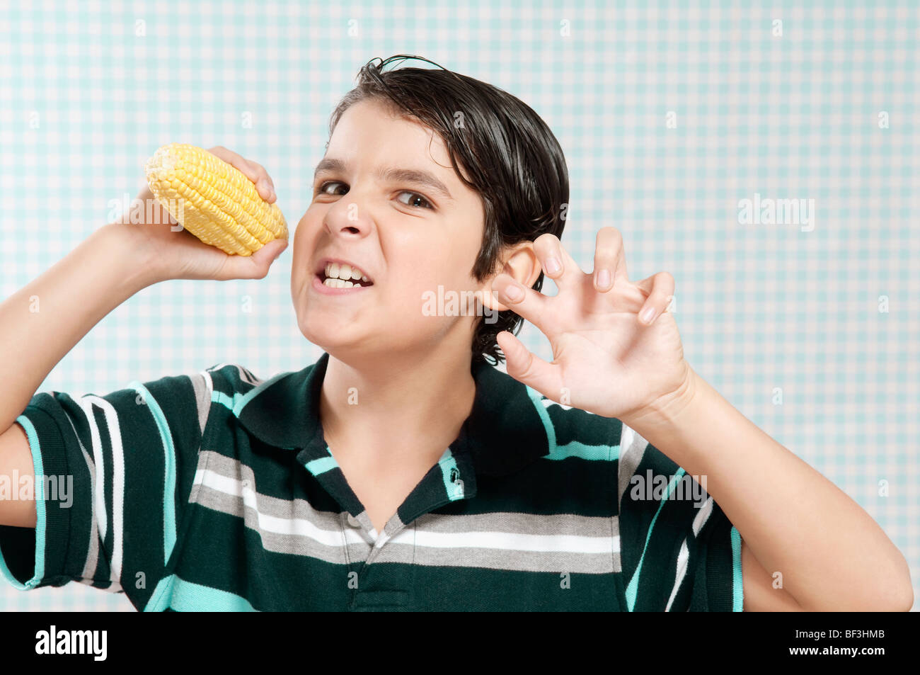 Boy holding a corn cob and looking angry Stock Photo - Alamy