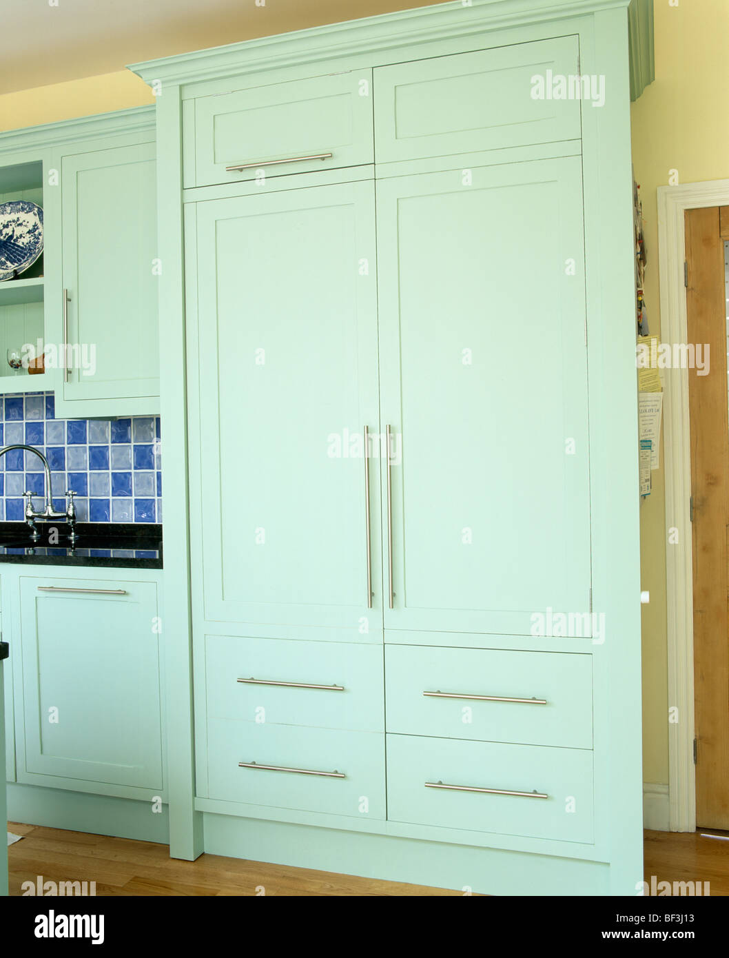 Close-up of pastel green storage unit in traditional country kitchen ...