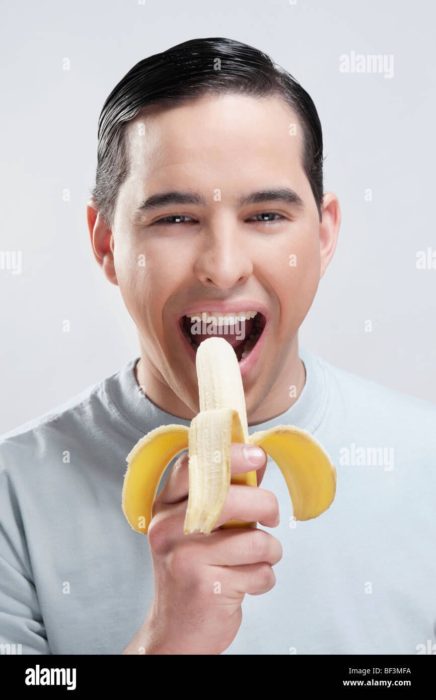 Portrait of a man eating a banana Stock Photo - Alamy