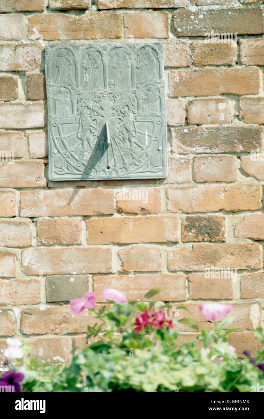 Close-up of old lead sun-dial on brick garden wall Stock Photo - Alamy