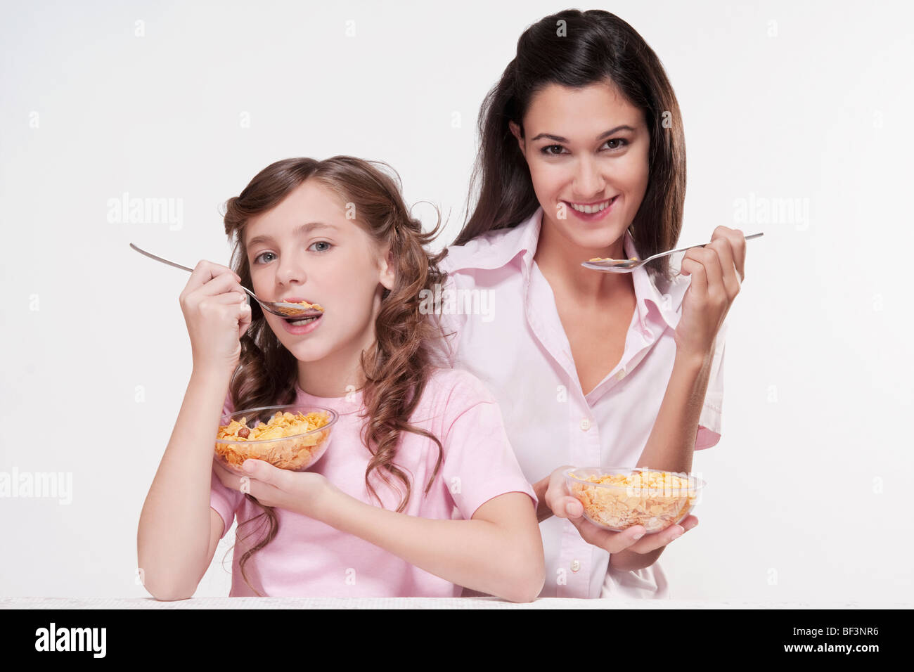 Portrait of a woman and her daughter eating cornflakes Stock Photo - Alamy