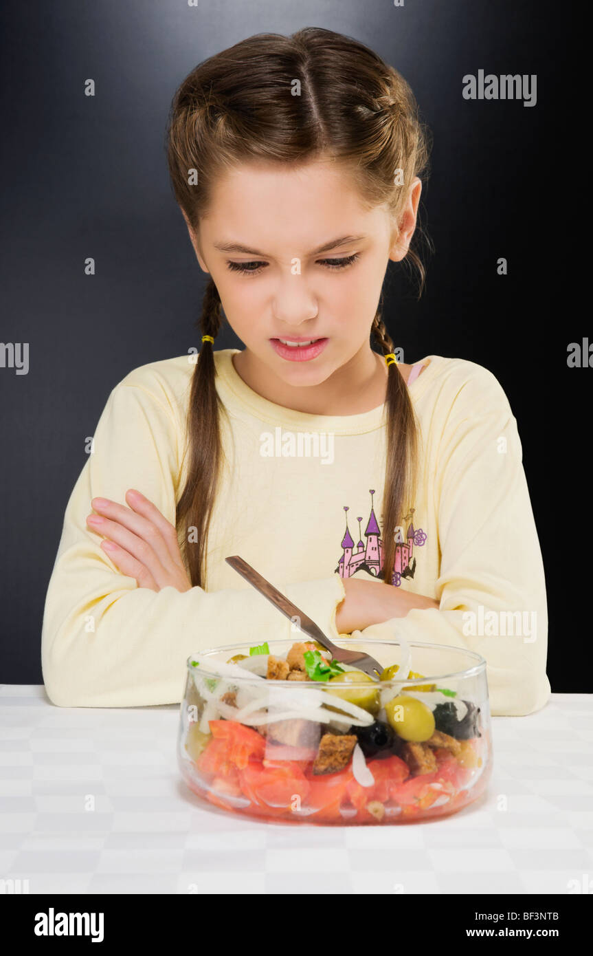Frowning girl sitting table hi-res stock photography and images - Alamy