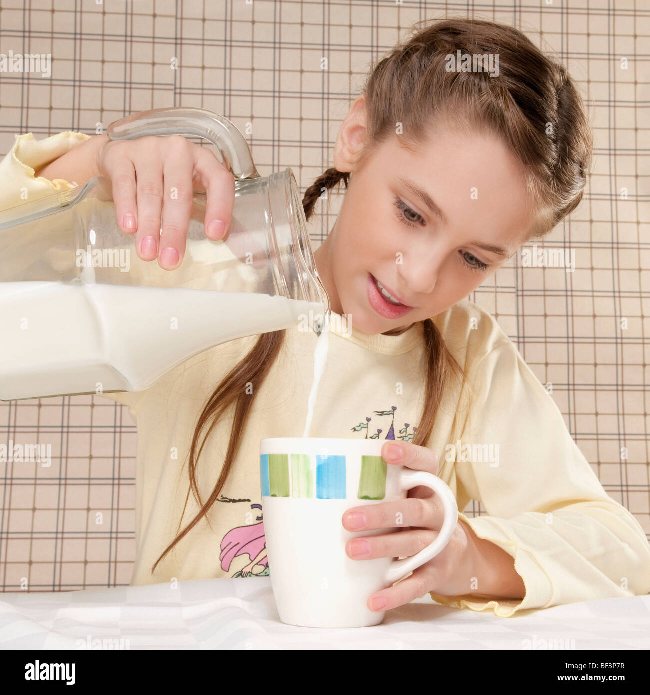 Girl pouring milk into a cup Stock Photo - Alamy