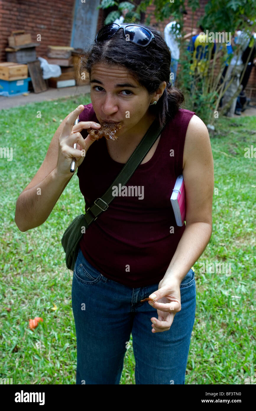 Woman eating honey from a bee hive at University of Vi cosa, Vi cosa ...