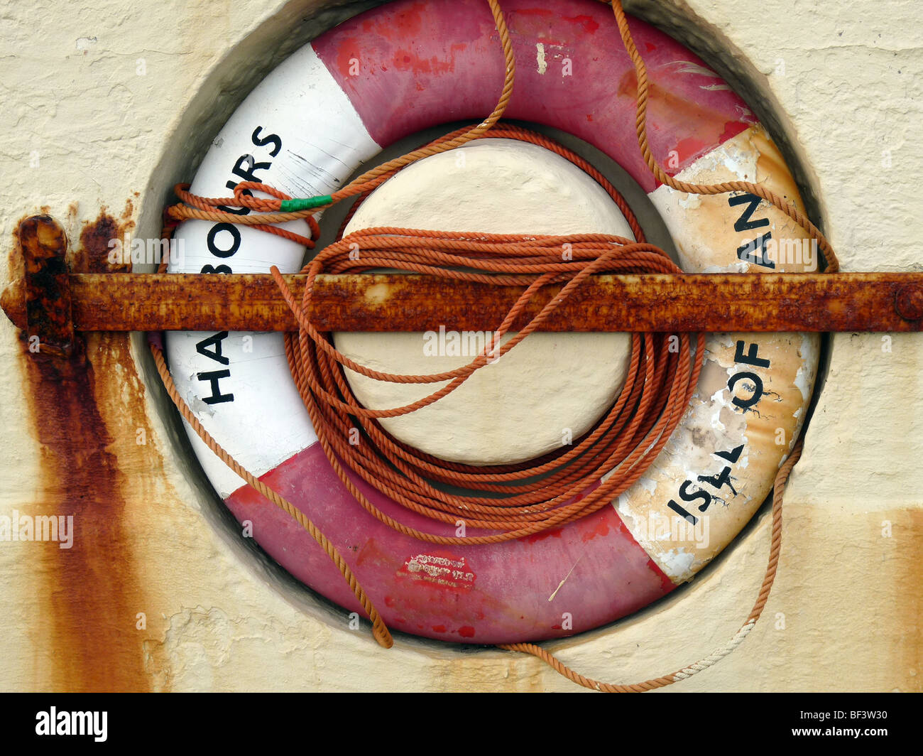 A faded life belt saying ' Harbours Isle of Man' with a neatly coiled ...