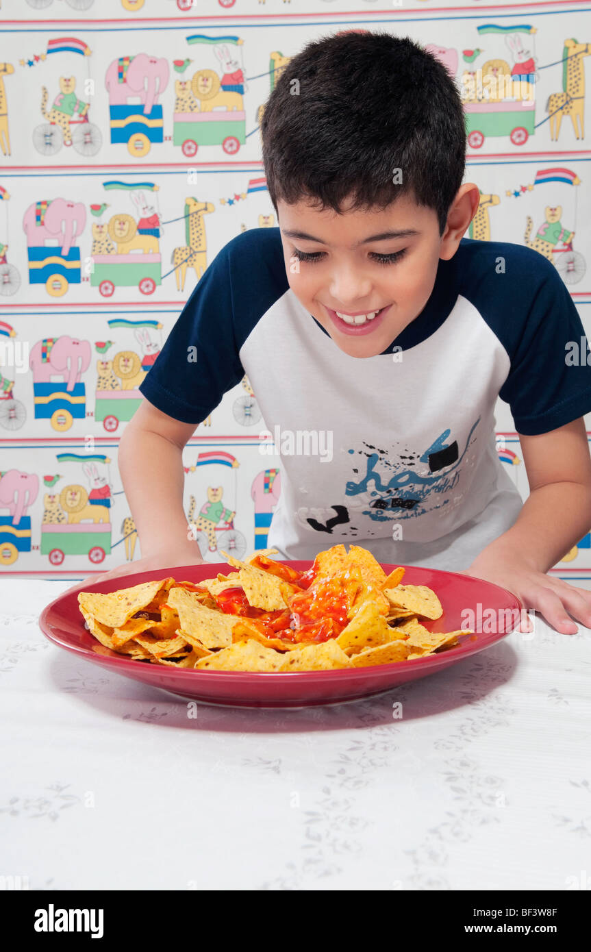 Close-up of a boy looking at a platter of nachos Stock Photo - Alamy