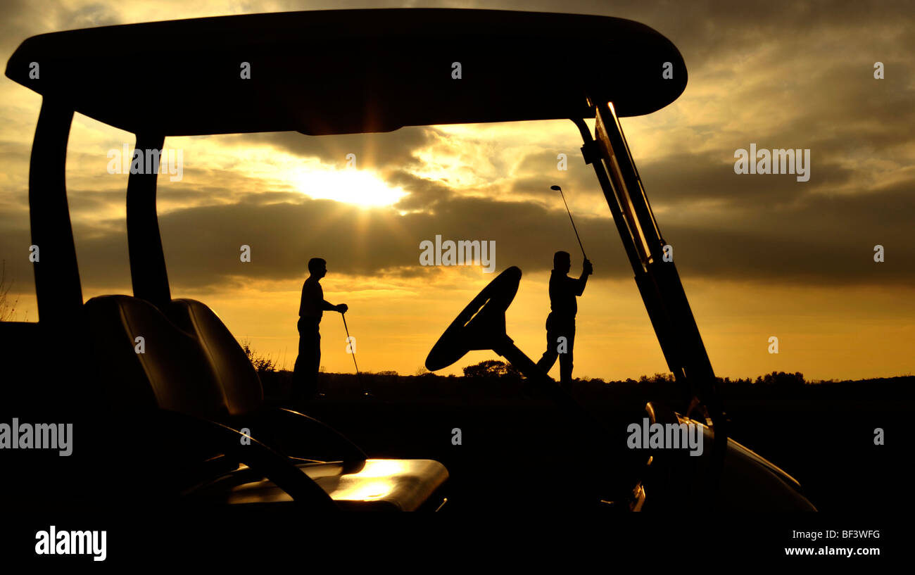 Golfers at sunset Stock Photo - Alamy