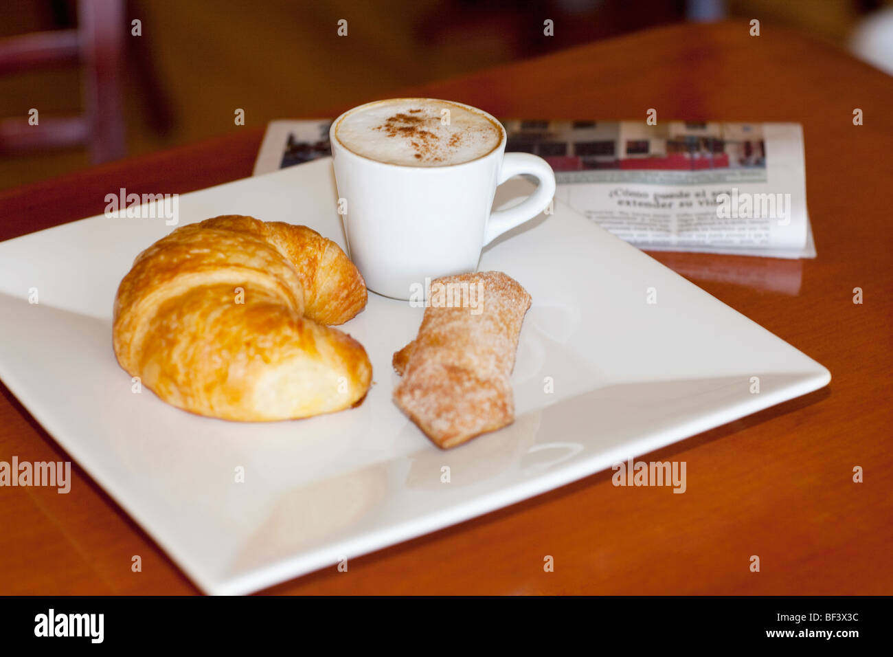 High angle view of a croissant and sugar cracker with a cup of coffee ...
