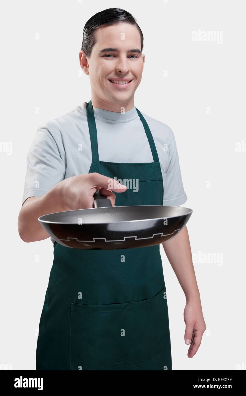 Portrait of a man holding a frying pan and smiling Stock Photo - Alamy