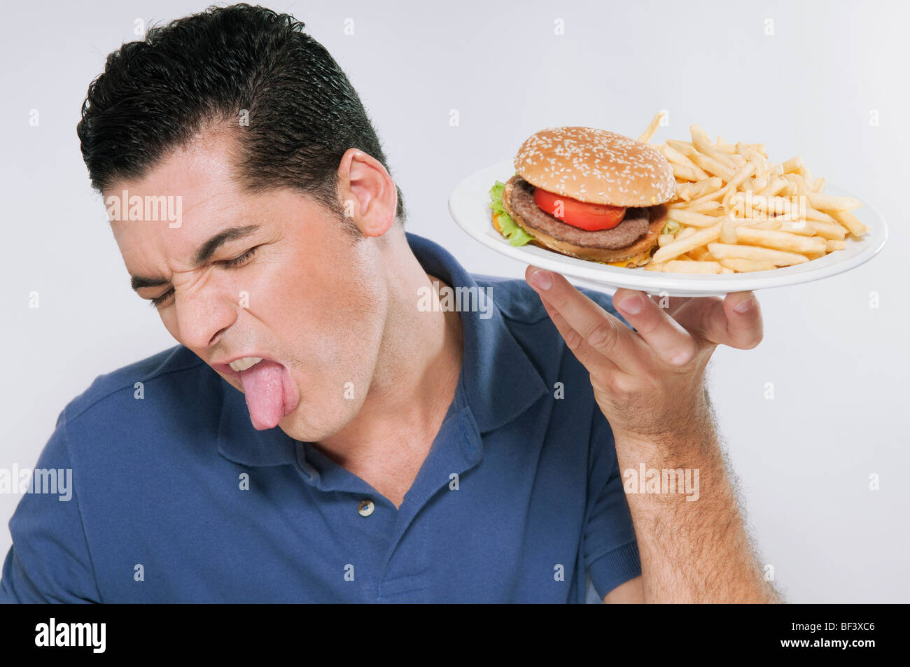 Man retching at a plate of hamburger and fries Stock Photo - Alamy