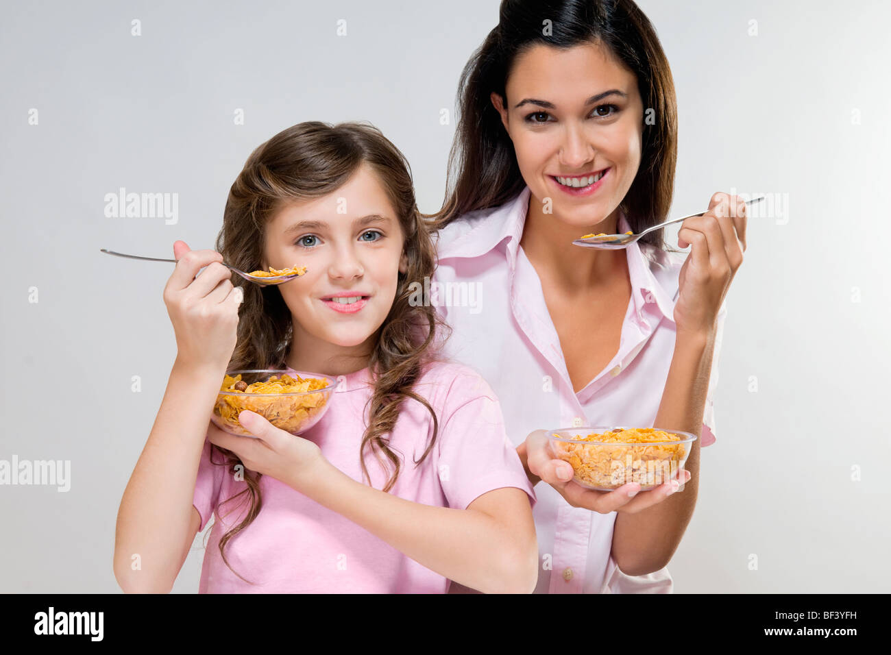 Portrait of mother and daughter eating cereal Stock Photo - Alamy