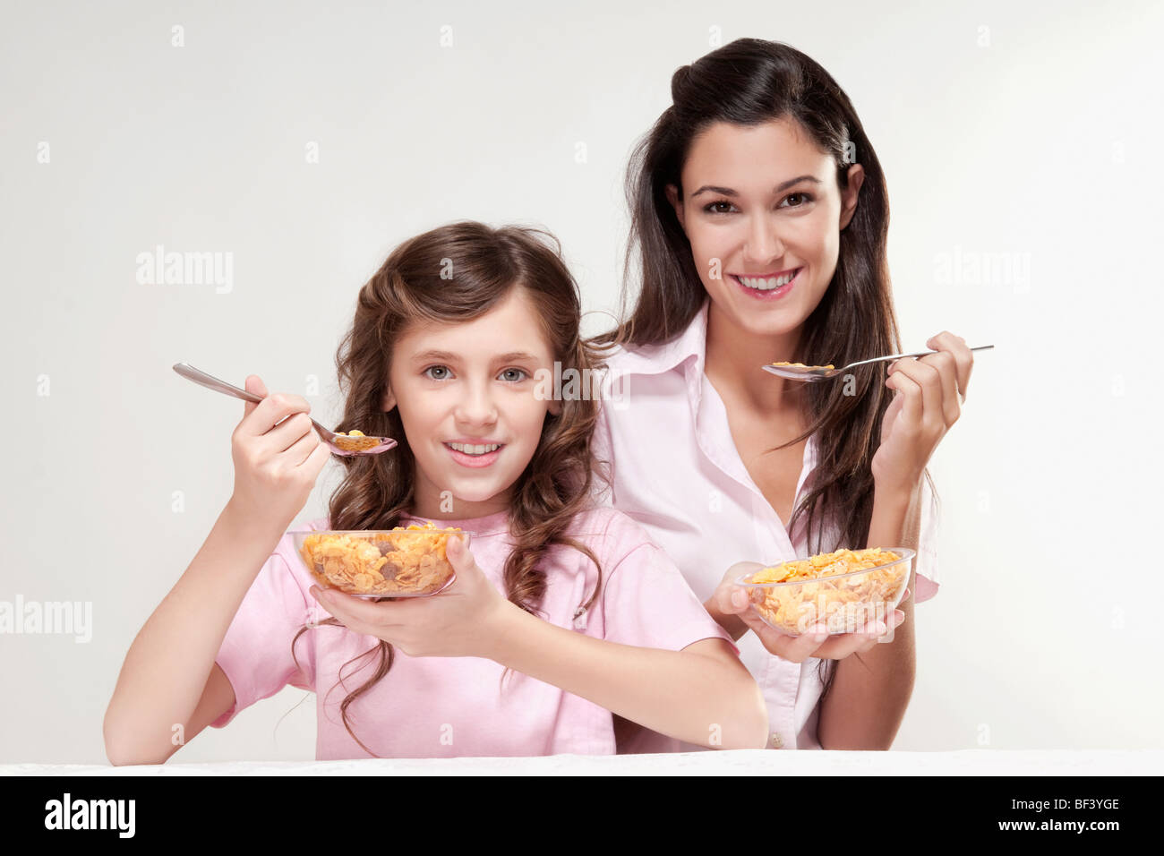 Portrait of a woman and her daughter eating cornflakes Stock Photo - Alamy