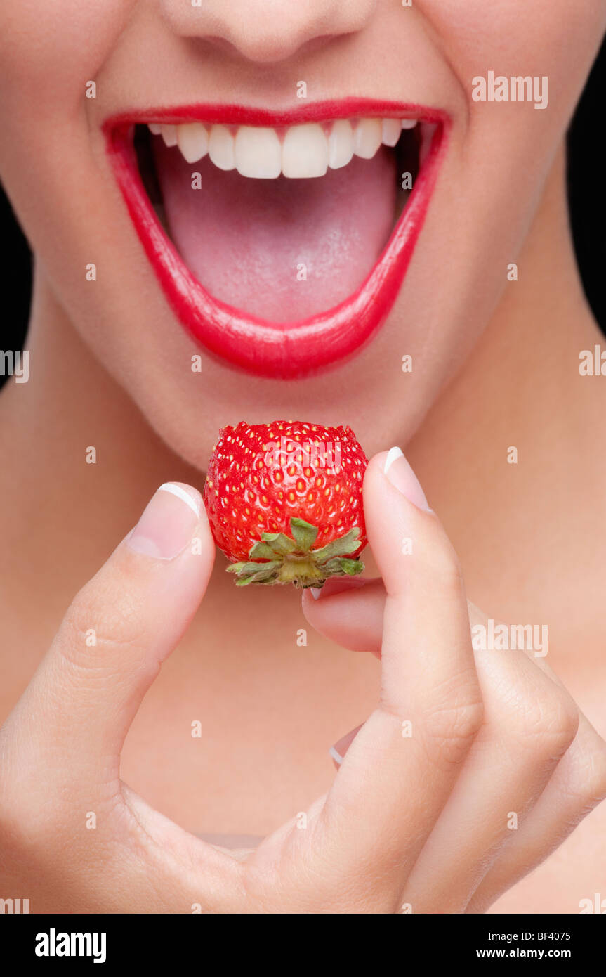 Close-up of a woman eating a strawberry Stock Photo - Alamy