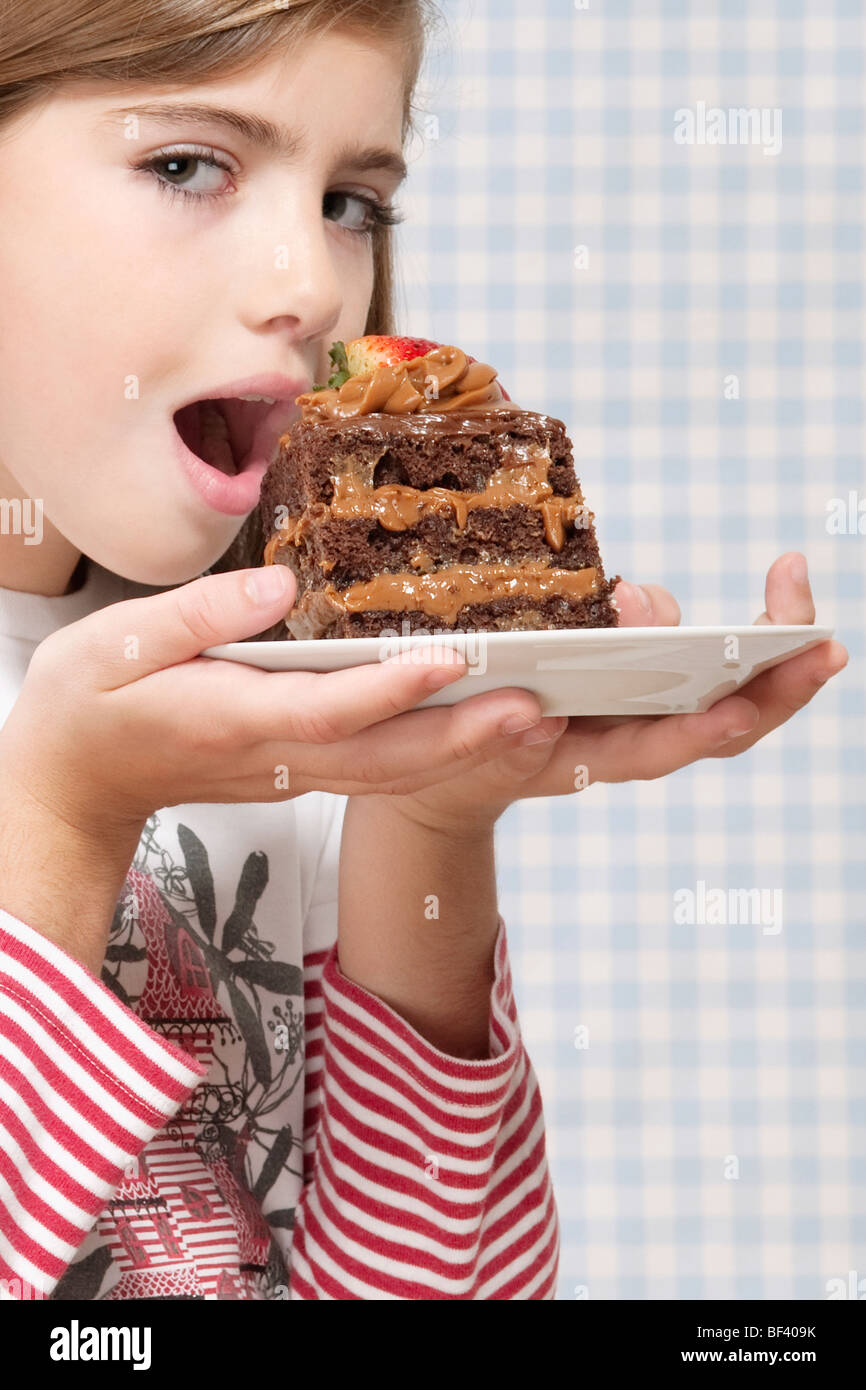 Girl eating a slice of chocolate pastry Stock Photo - Alamy