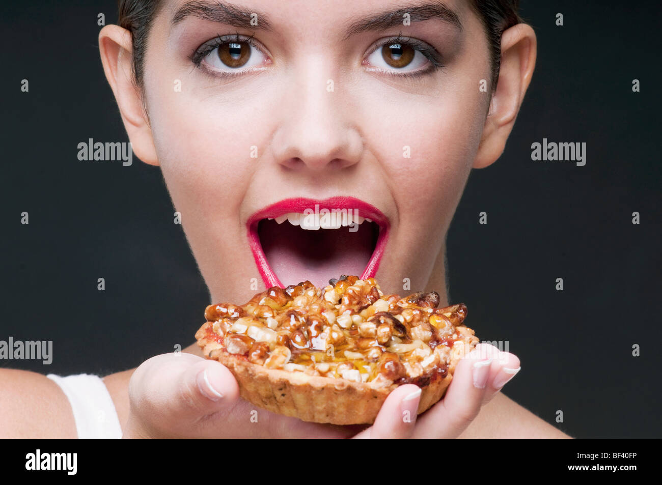 Woman eating a tart and smiling Stock Photo - Alamy