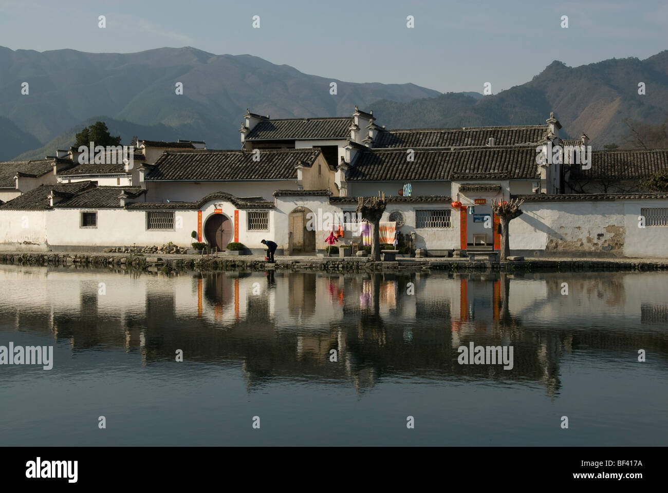 Traditional buildings reflected in the lake at the Hui-style village of ...