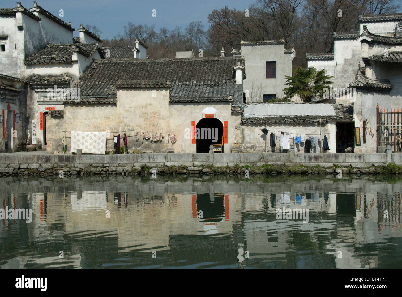 Traditional buildings reflected in the lake at the Hui-style village of ...