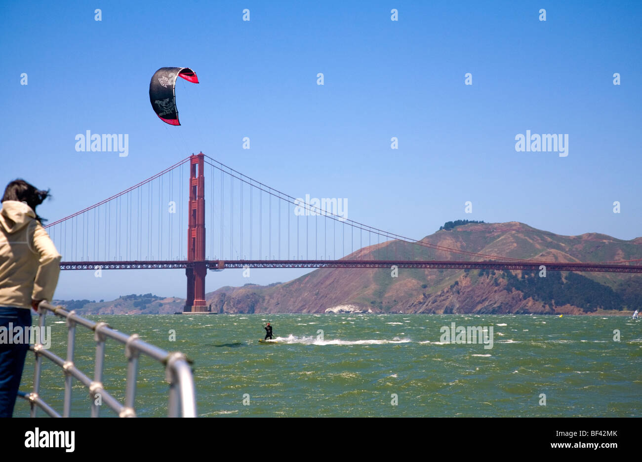 Kite Surfer at Golden Gate Bridge watched by girl on boat, San ...