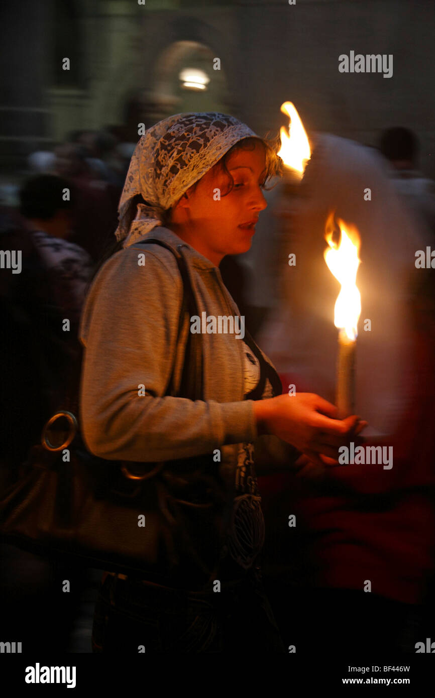 Woman carrying flaming torch as part of candle-lighting ritual at ...