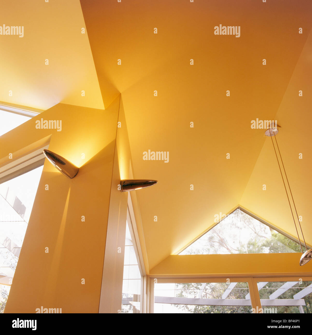Looking up at wall lights on yellow apex ceiling Stock Photo - Alamy