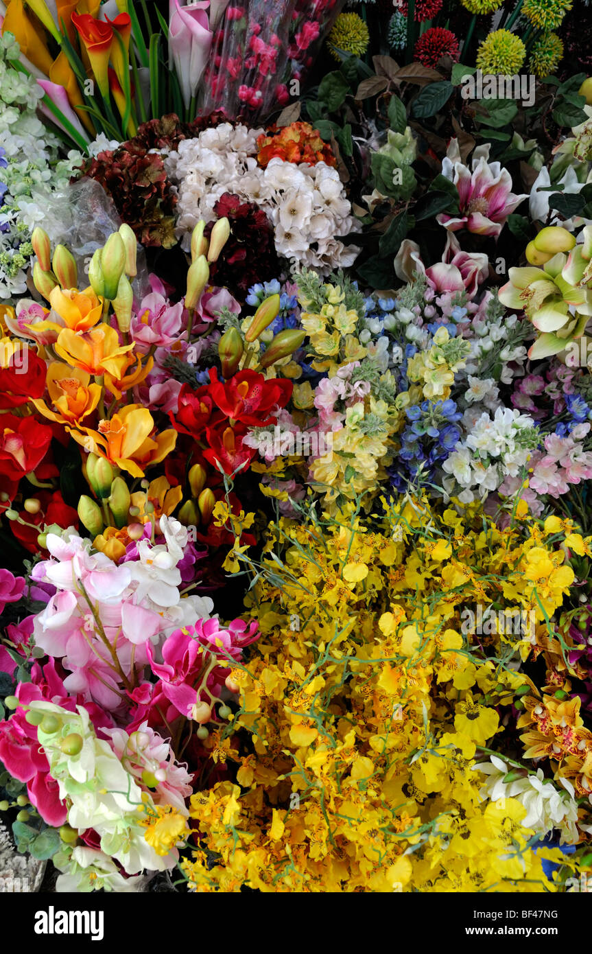 bunches of colorful colourful plastic fake artificial flowers blooms on ...