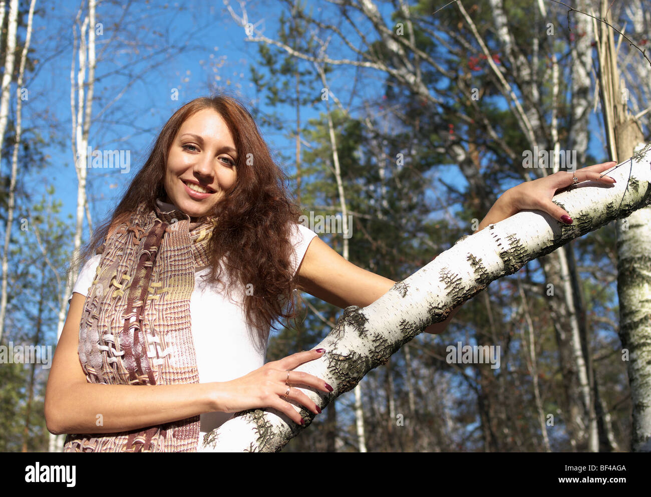 Beautiful young smiling woman with birch tree Stock Photo - Alamy