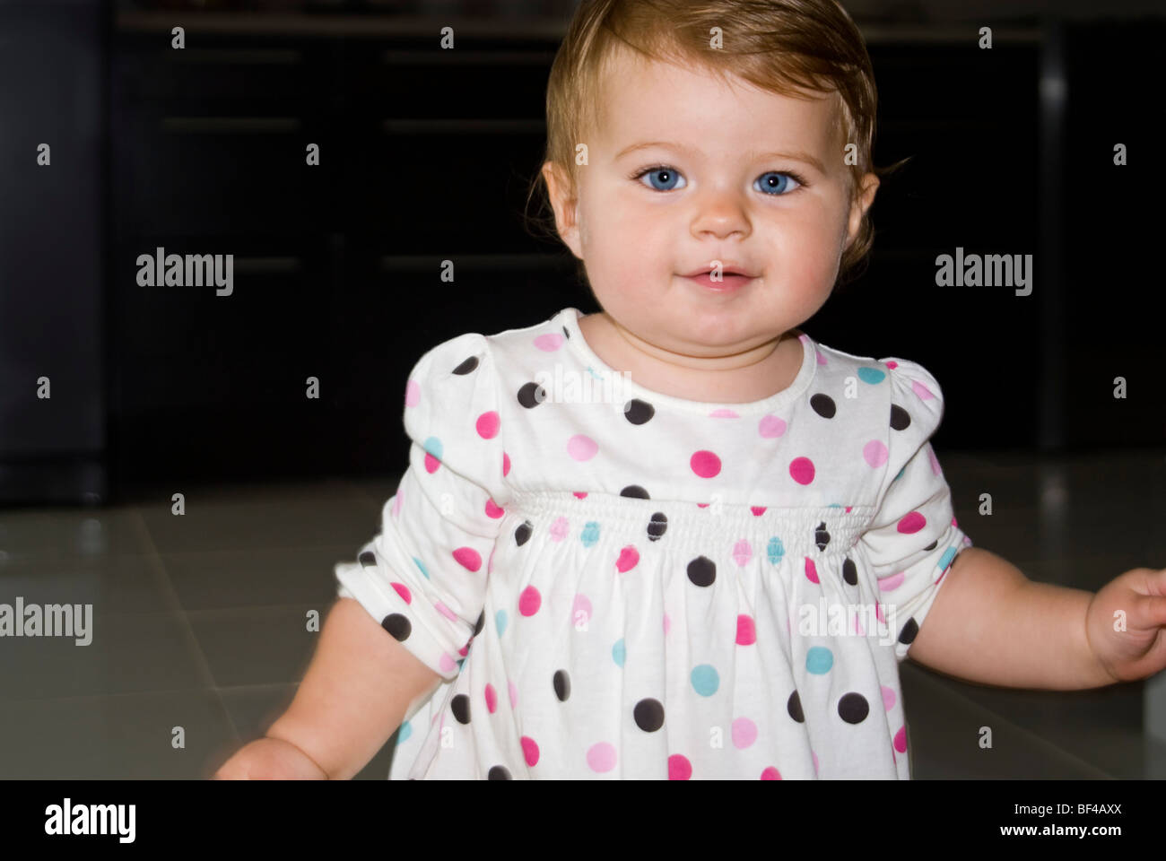 Horizontal close up portrait of a cute baby girl with bright blue eyes ...