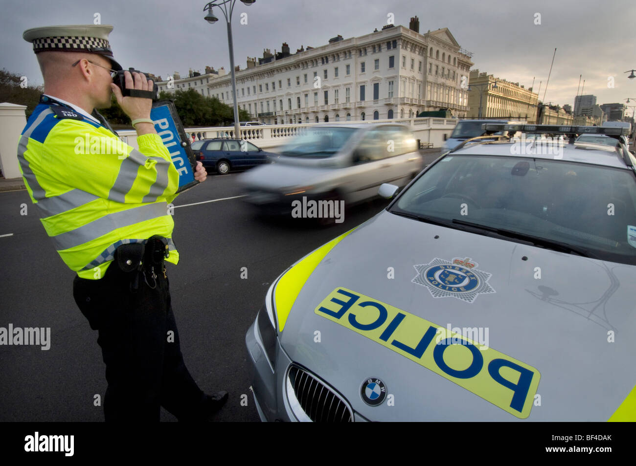 A police officer using a handheld laser camera on a city road to catch ...