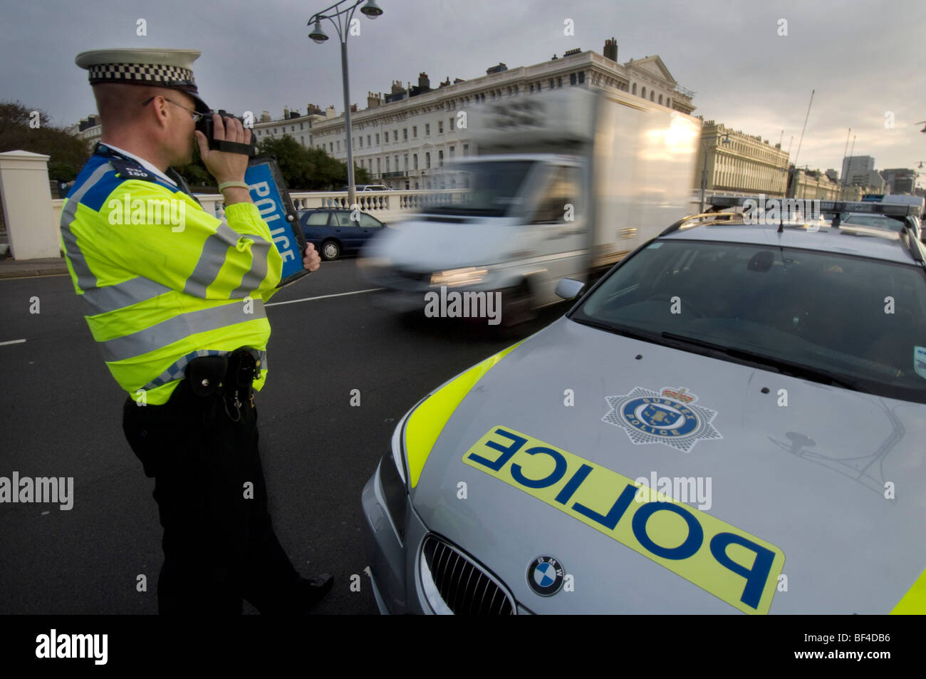 A police officer using a handheld laser camera on a city road to catch ...