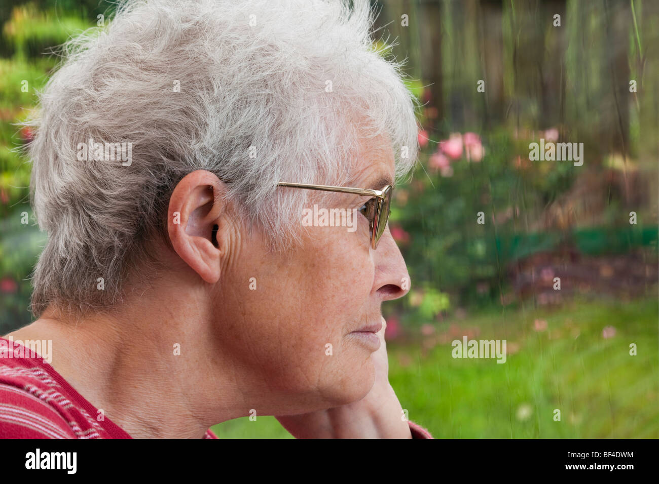 Elderly senior woman OAP lady with a despondent expression looking out ...