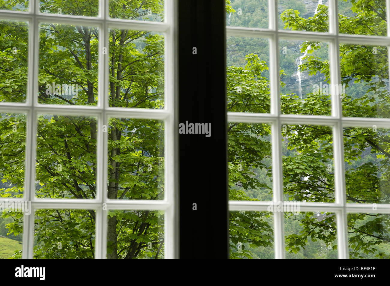 forest and waterfall seen through classic Norwegian window, Geiranger ...