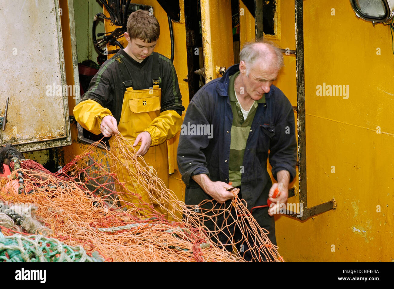fisherman repairing net, Dunmore East, Ireland Stock Photo - Alamy