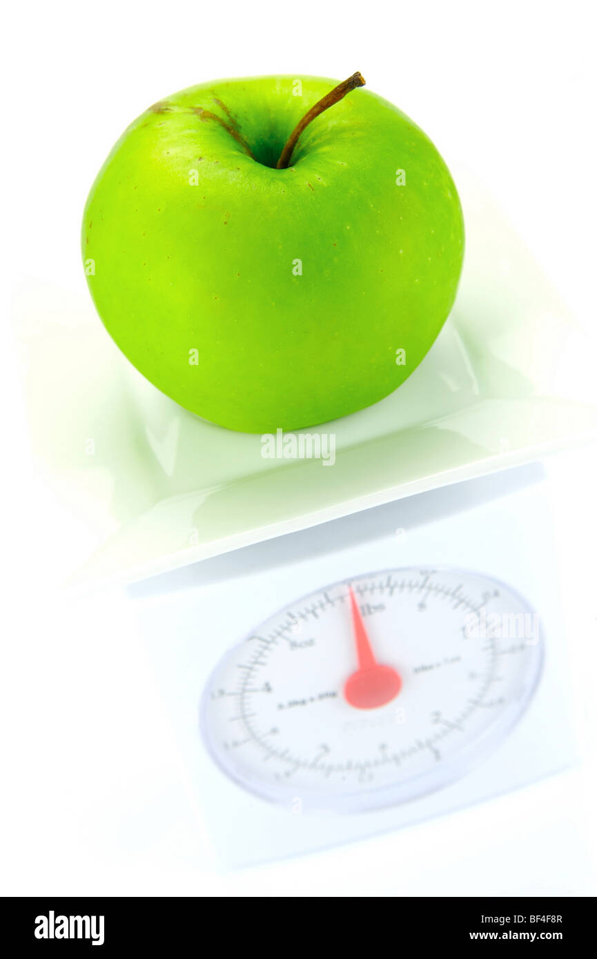 An apple and a set of scales isolated against a white background Stock ...