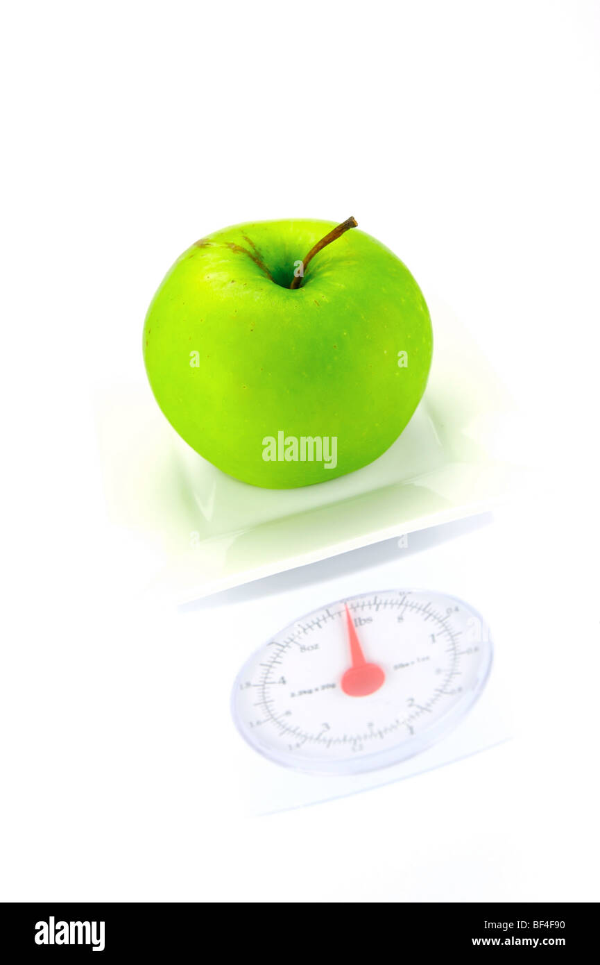 An apple and a set of scales isolated against a white background Stock ...